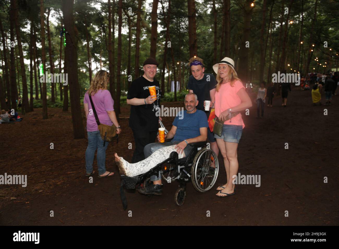 A man with a broken leg is helped around by his friends at the 2014 ...