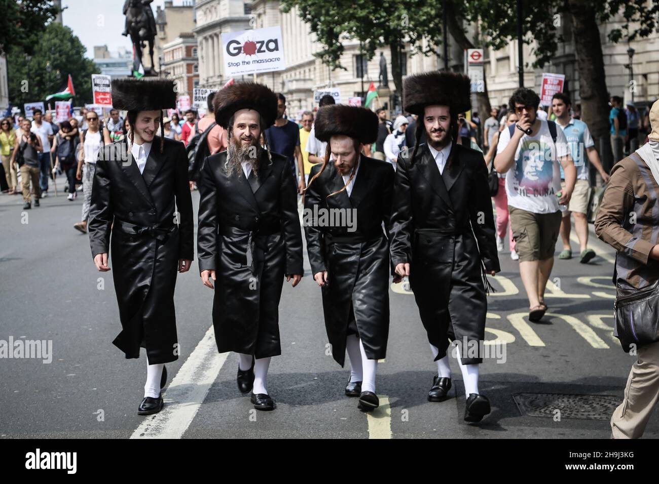 Four Orthodox jews in traditional dress join a march in support of ...
