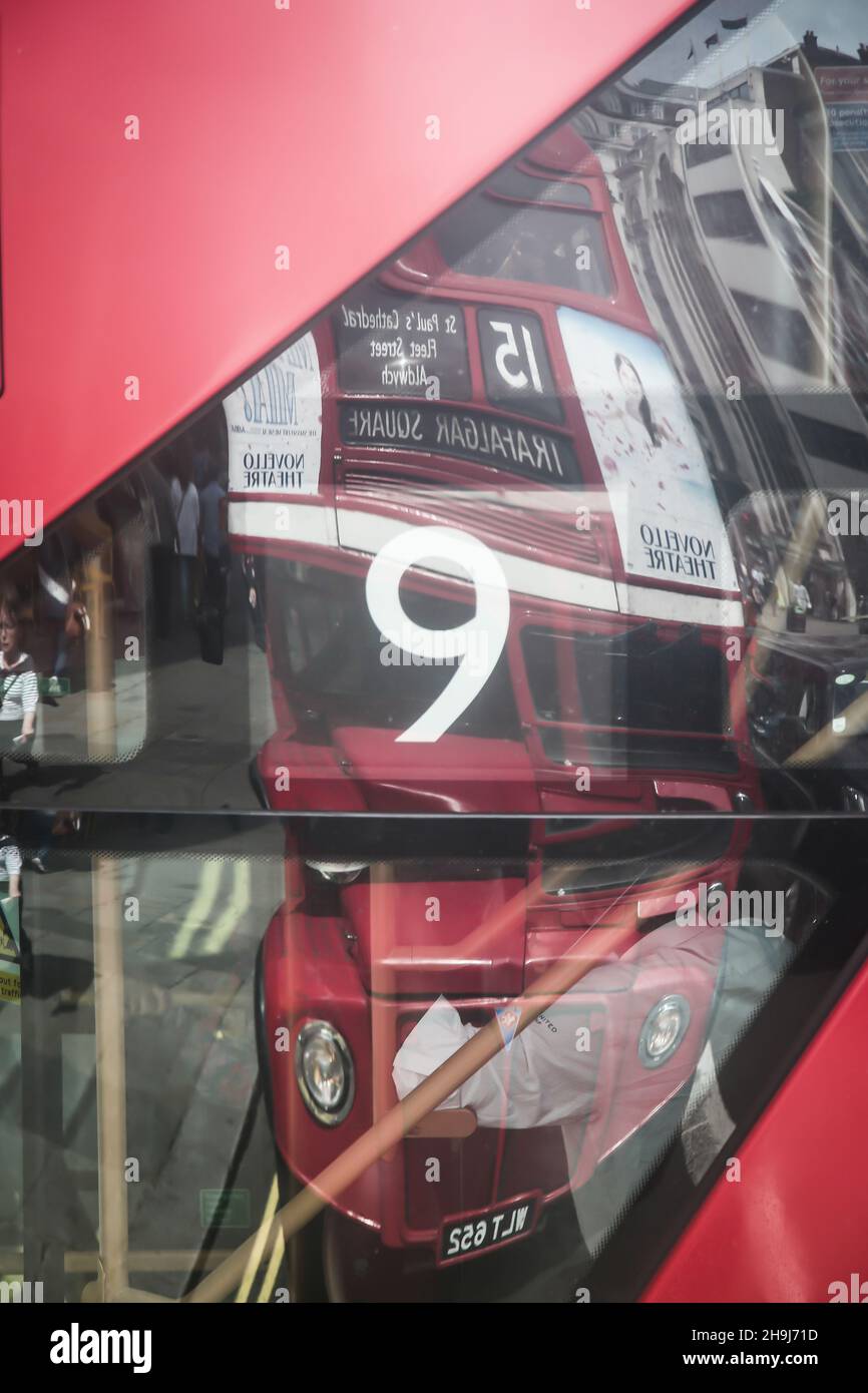 The reflection of an old Routemaster bus in the rear of a new double ...