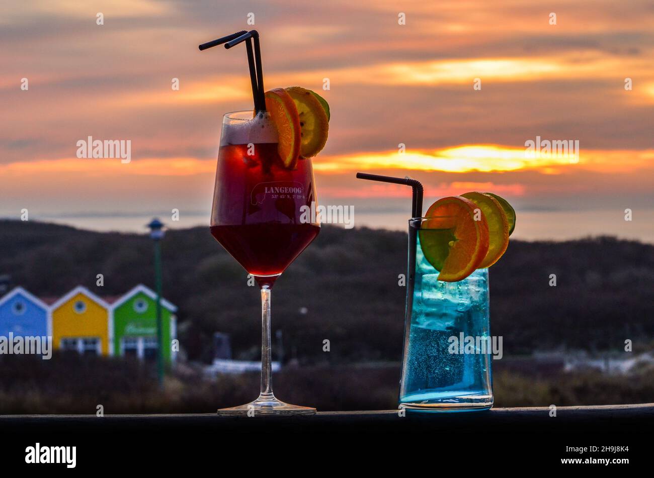 Colored cocktails with sunset sky on the background Stock Photo - Alamy