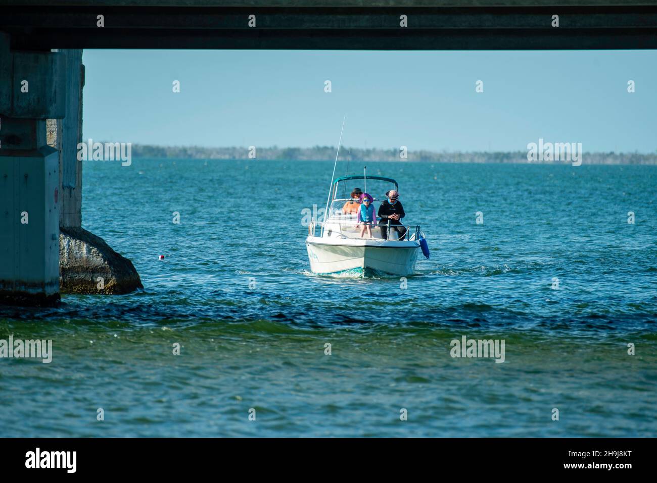 A family rides on a boat under the Overseas Highway near Big Pine Key ...