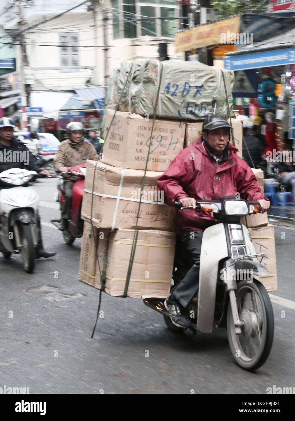 A man transporting boxes on a moped on the streets of Hanoi in Vietnam ...