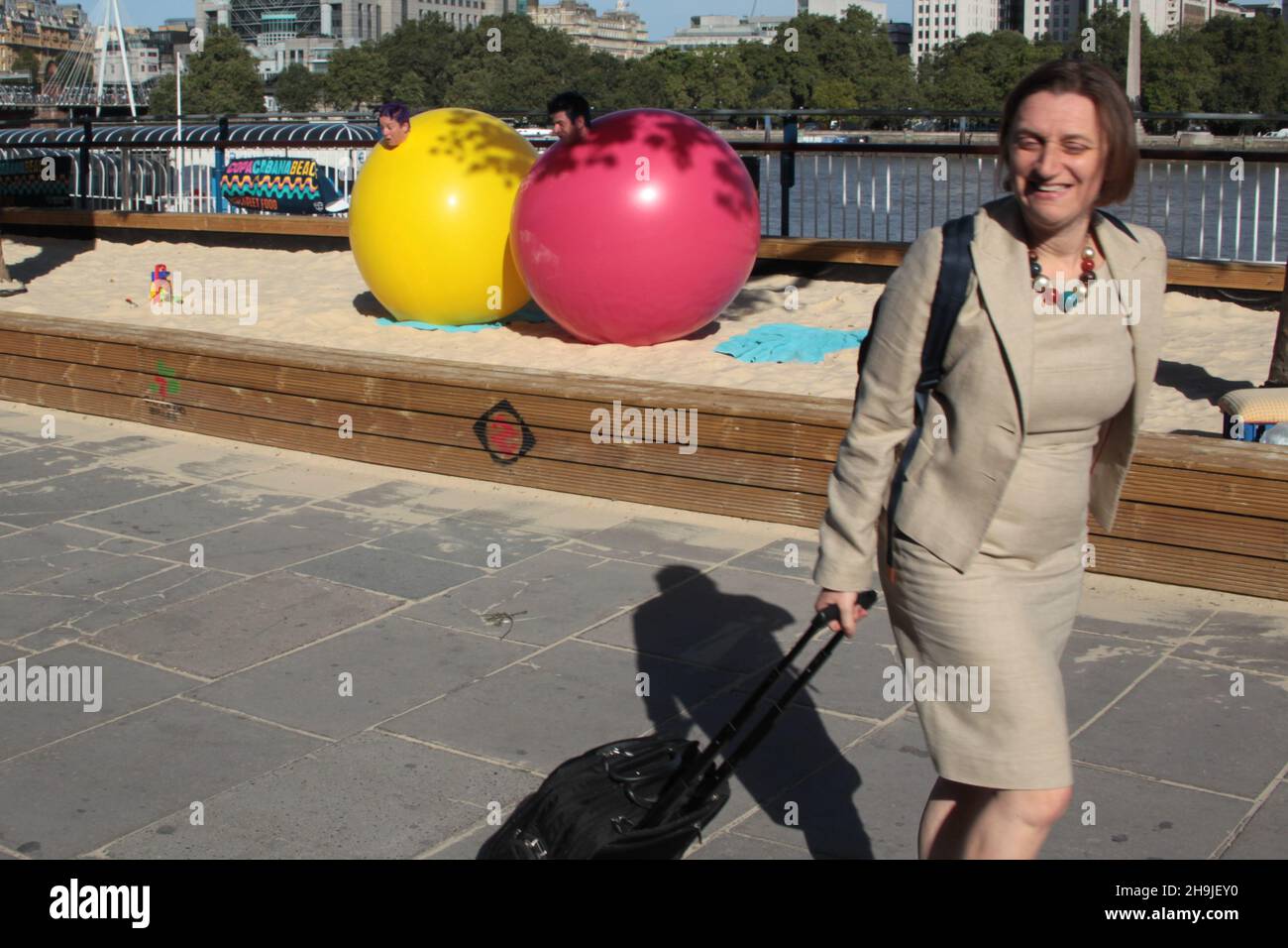 A passer-by laughing at New York clown duo Acrobuffos performing part ...