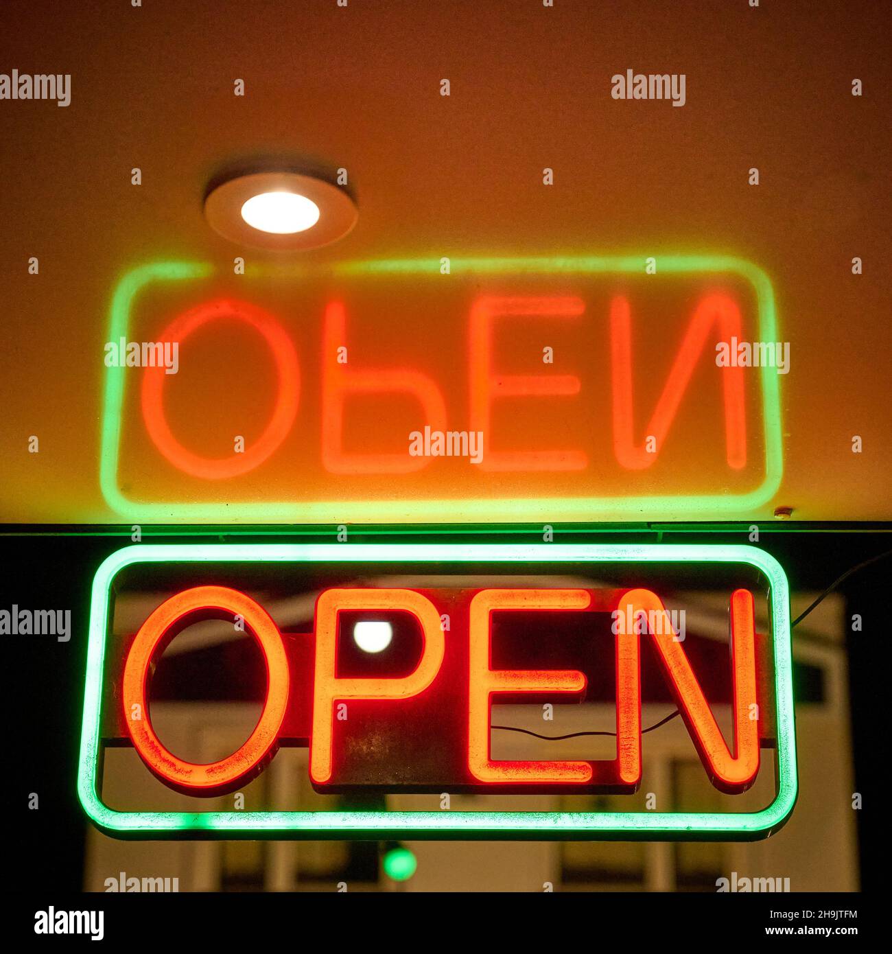 Neon open sign at night reflected in ceiling Stock Photo - Alamy