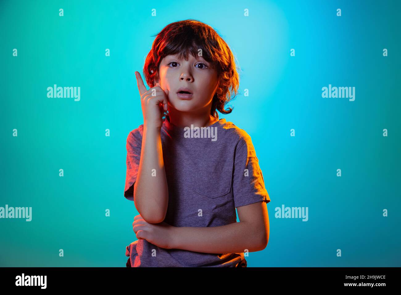 Half-length portrait of little boy, kid raising finger up isolated on ...