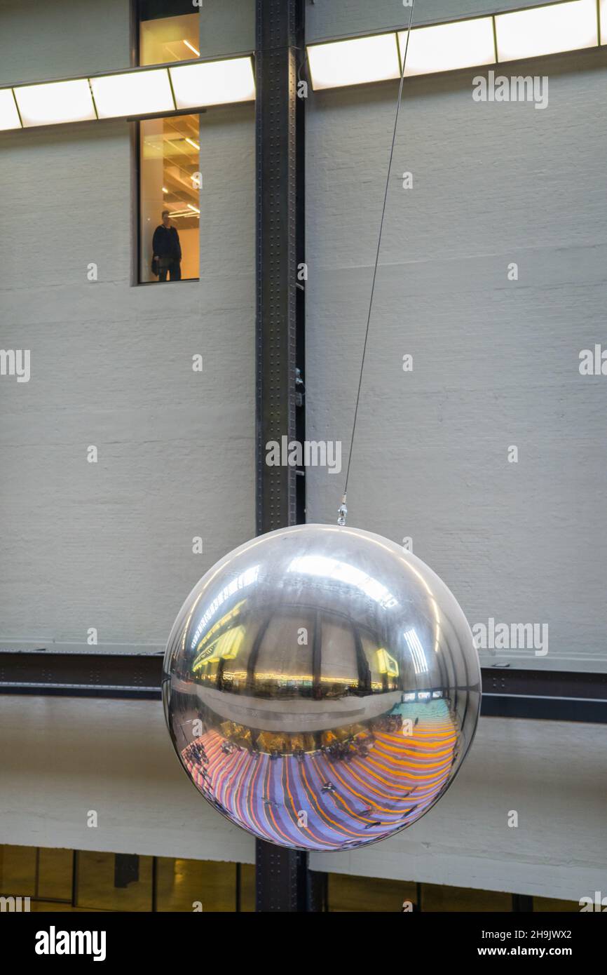 A huge reflective metal ball swings in the Turbine Hall of the Tate ...