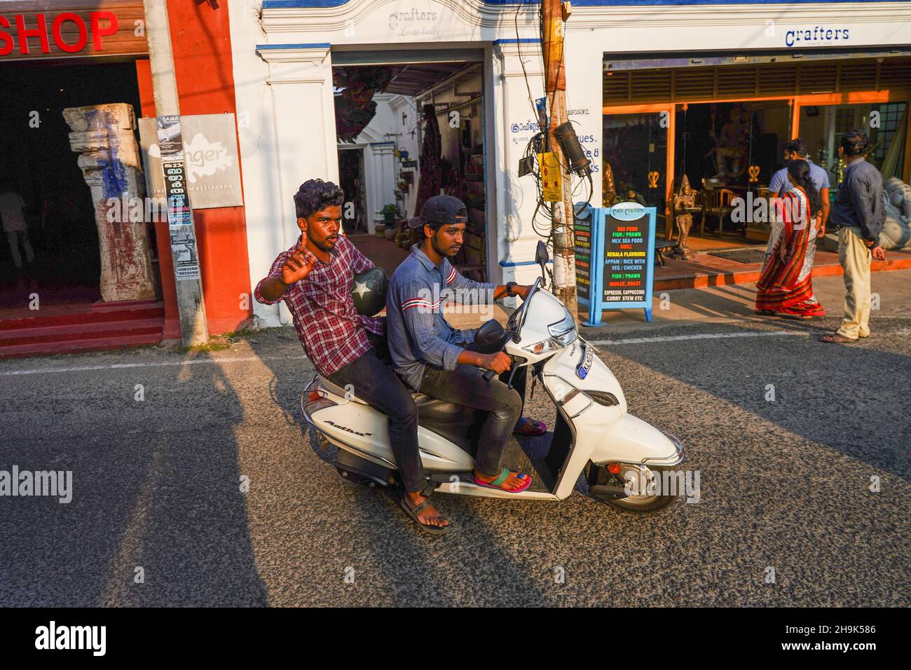Views of riders of motorcycles and mopeds in Cochin, Kerala. From a ...