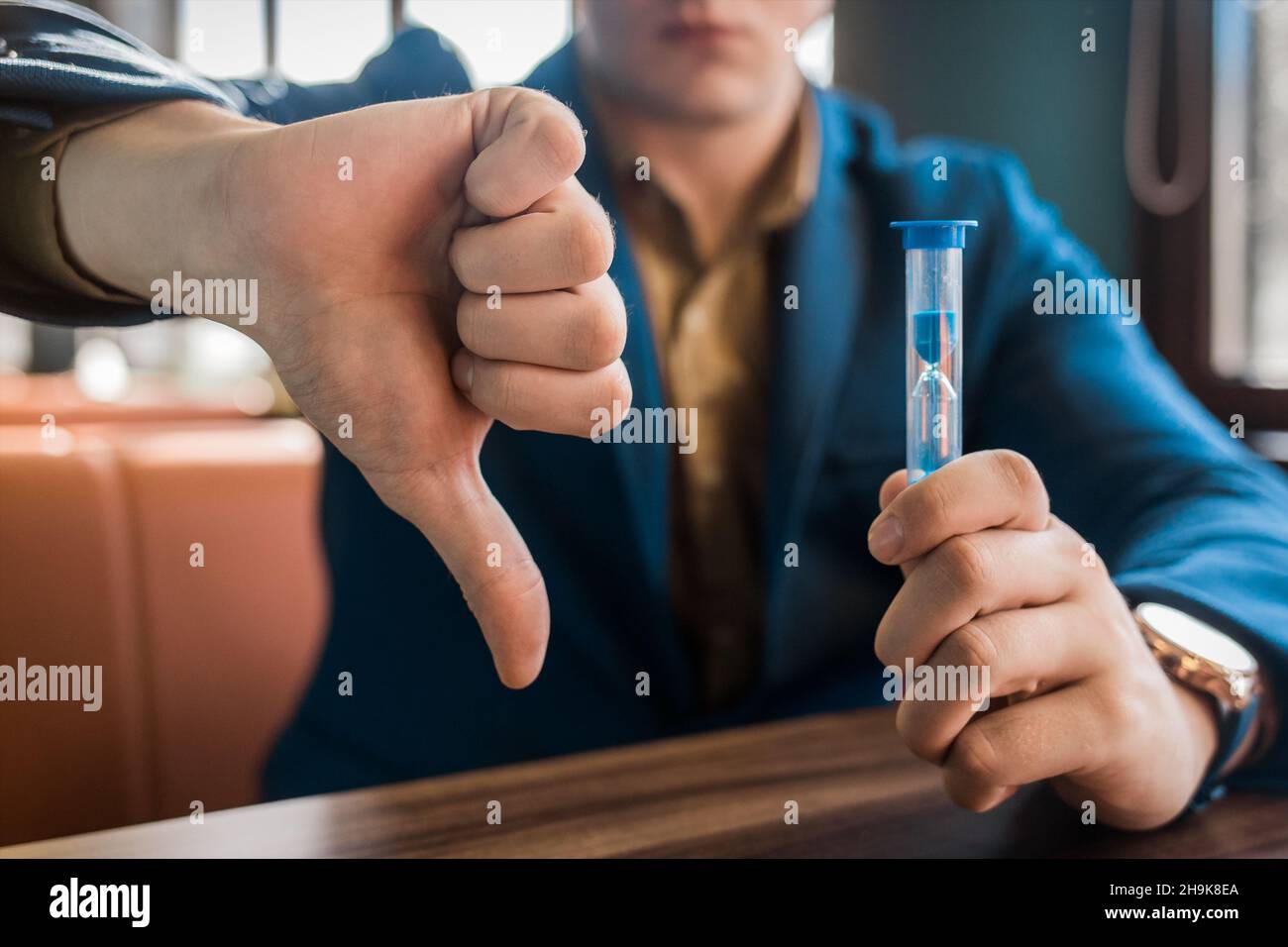 The hand of a serious businessman shows a bad gesture of a finger down ...