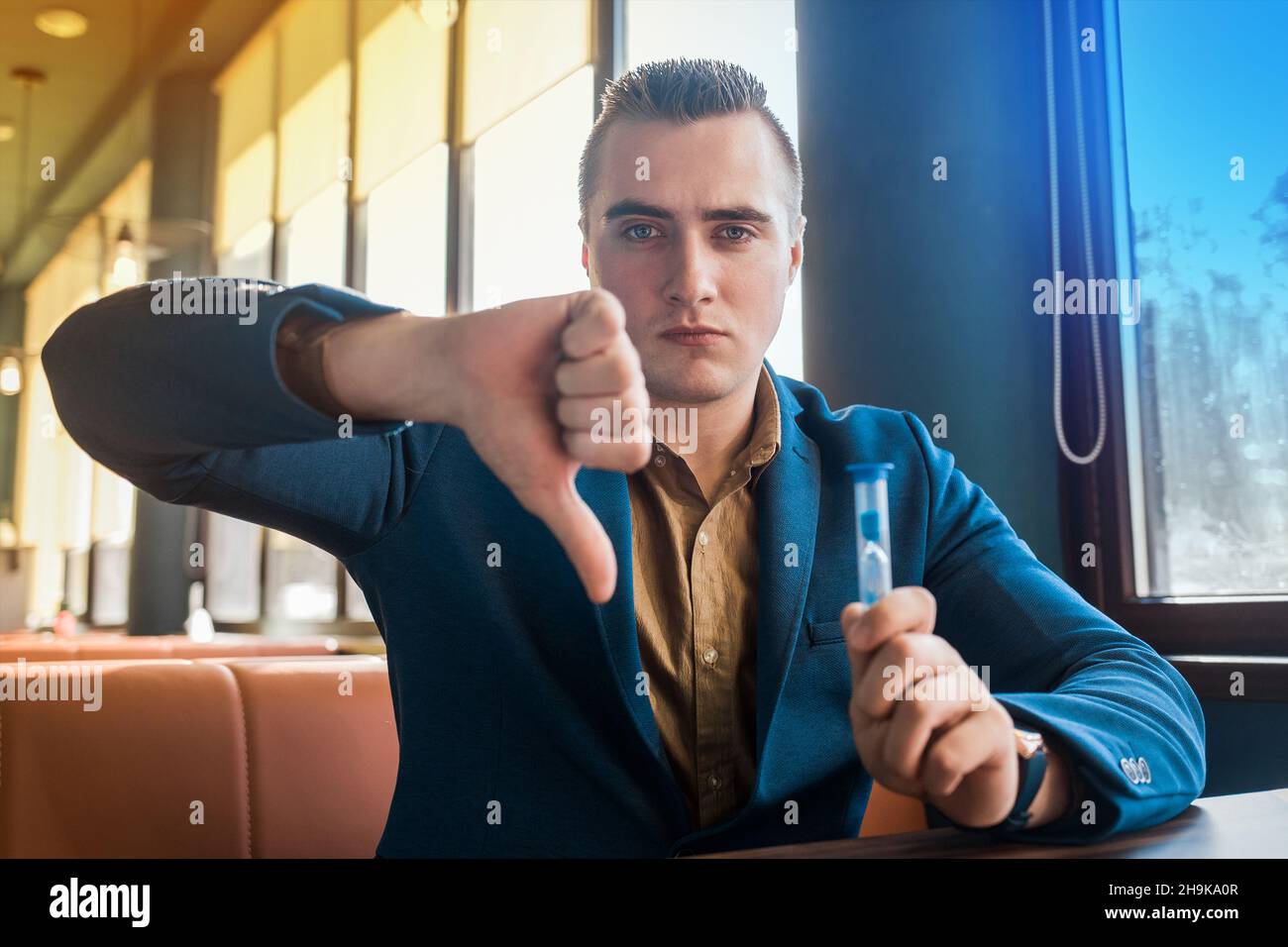 The hand of a serious businessman shows a bad gesture of a finger down ...