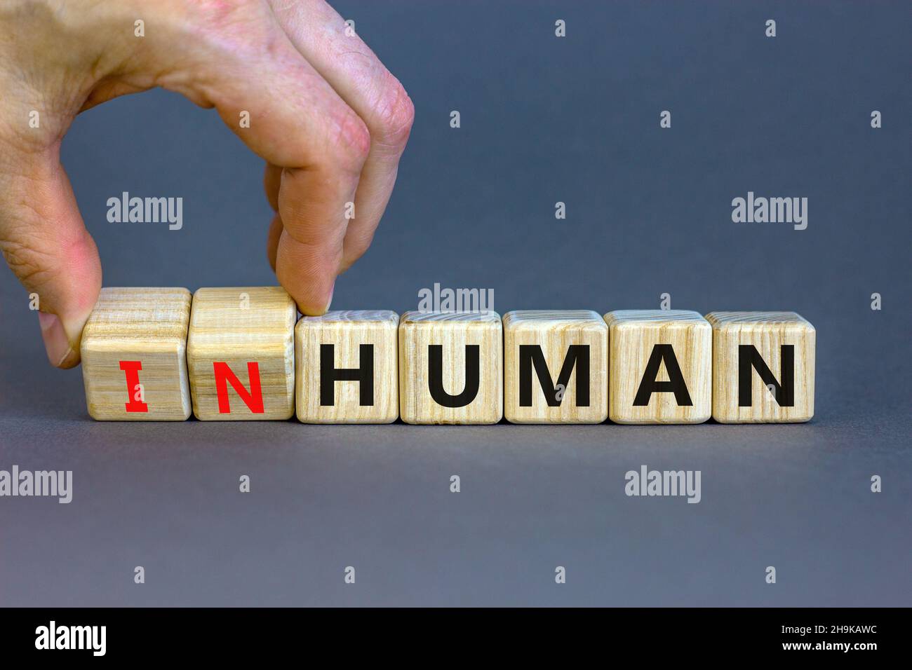 Human or inhuman symbol. Businessman turns wooden cubes and changes the ...