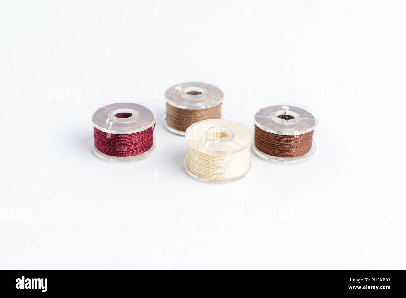 Different spools of mixed beige and brown cotton thread prepared for ...