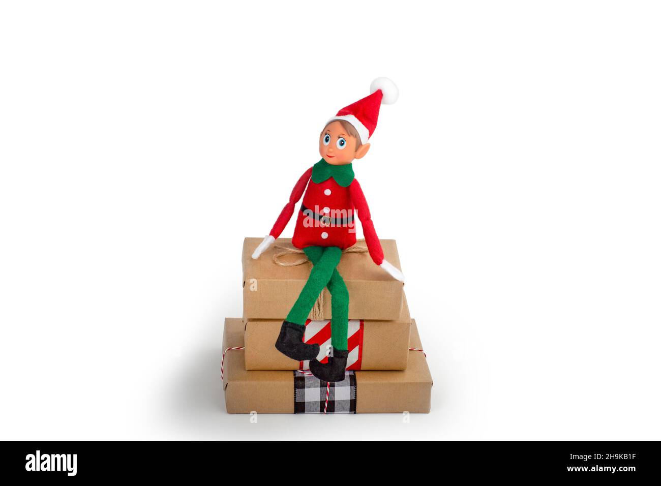 Christmas Elf sitting on a stack of gift boxes on an isolated white ...