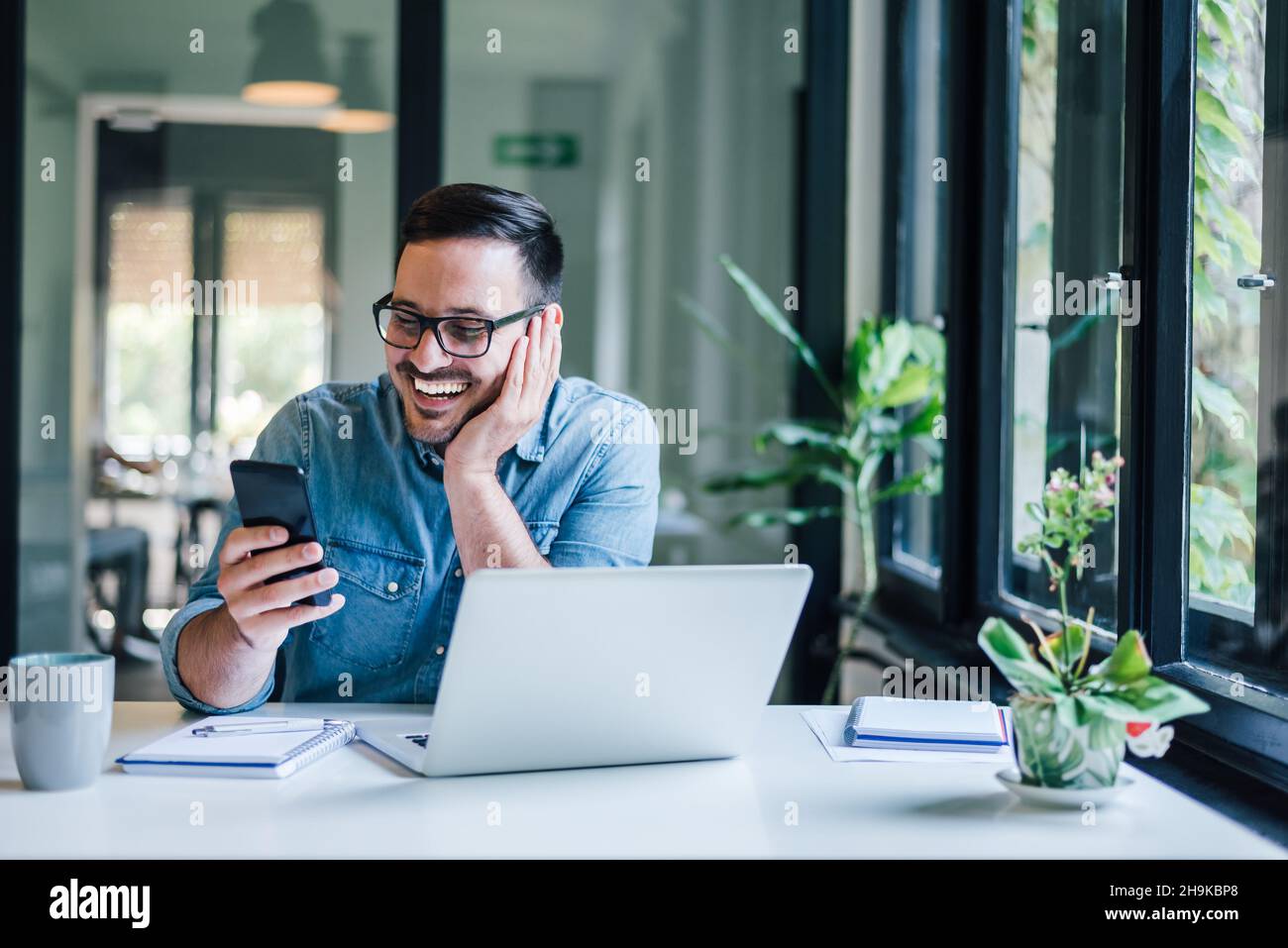 Smiling businessman using phone in home or office. Small business ...