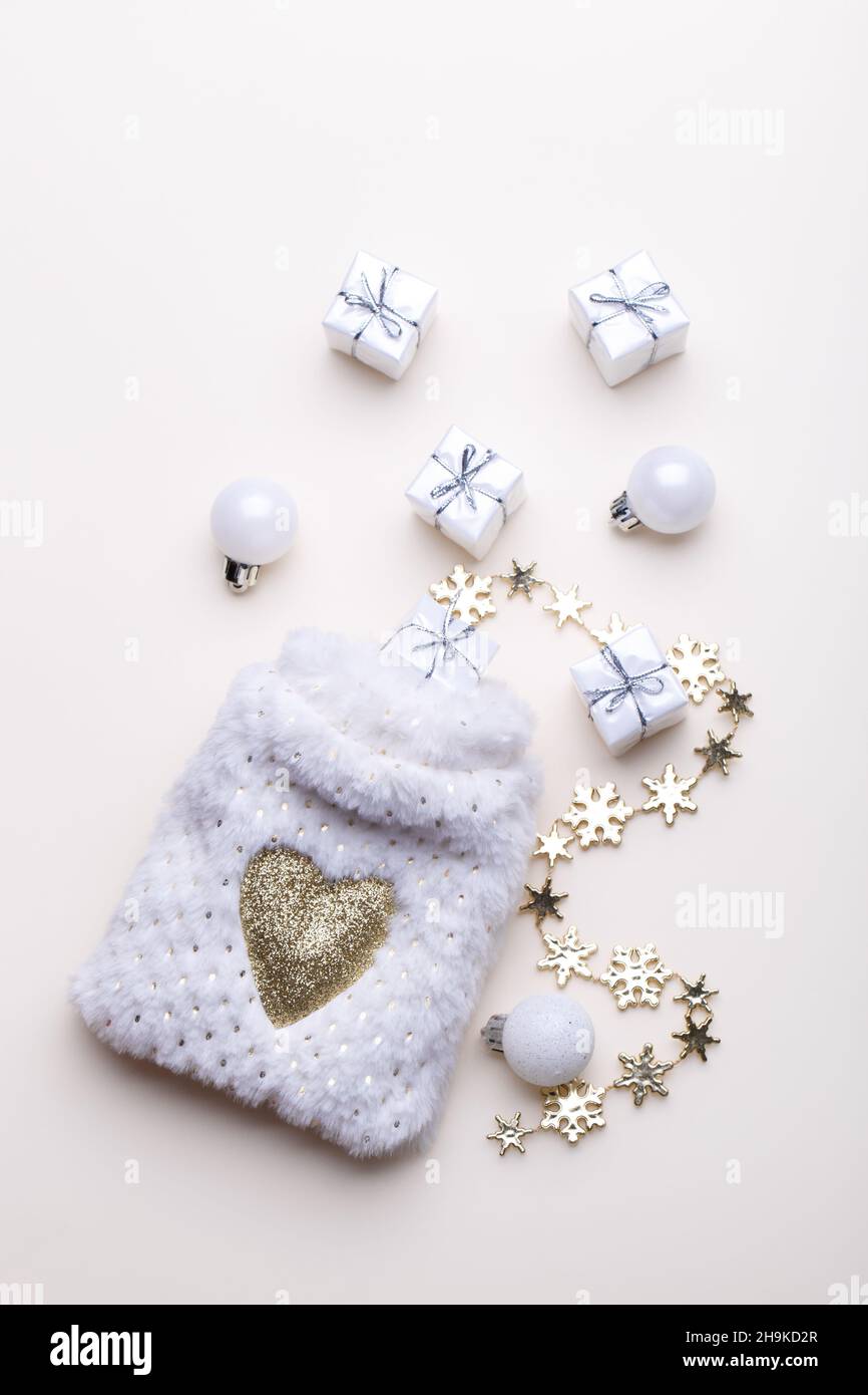 White fluffy sack with small gift boxes on beige background, flat lay ...