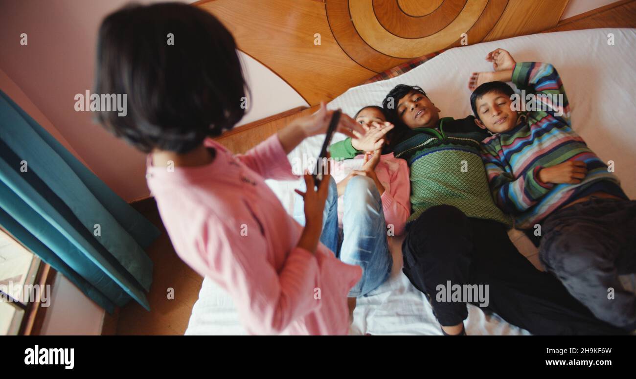 Soft focus of four Indian siblings staying indoors during lockdown ...