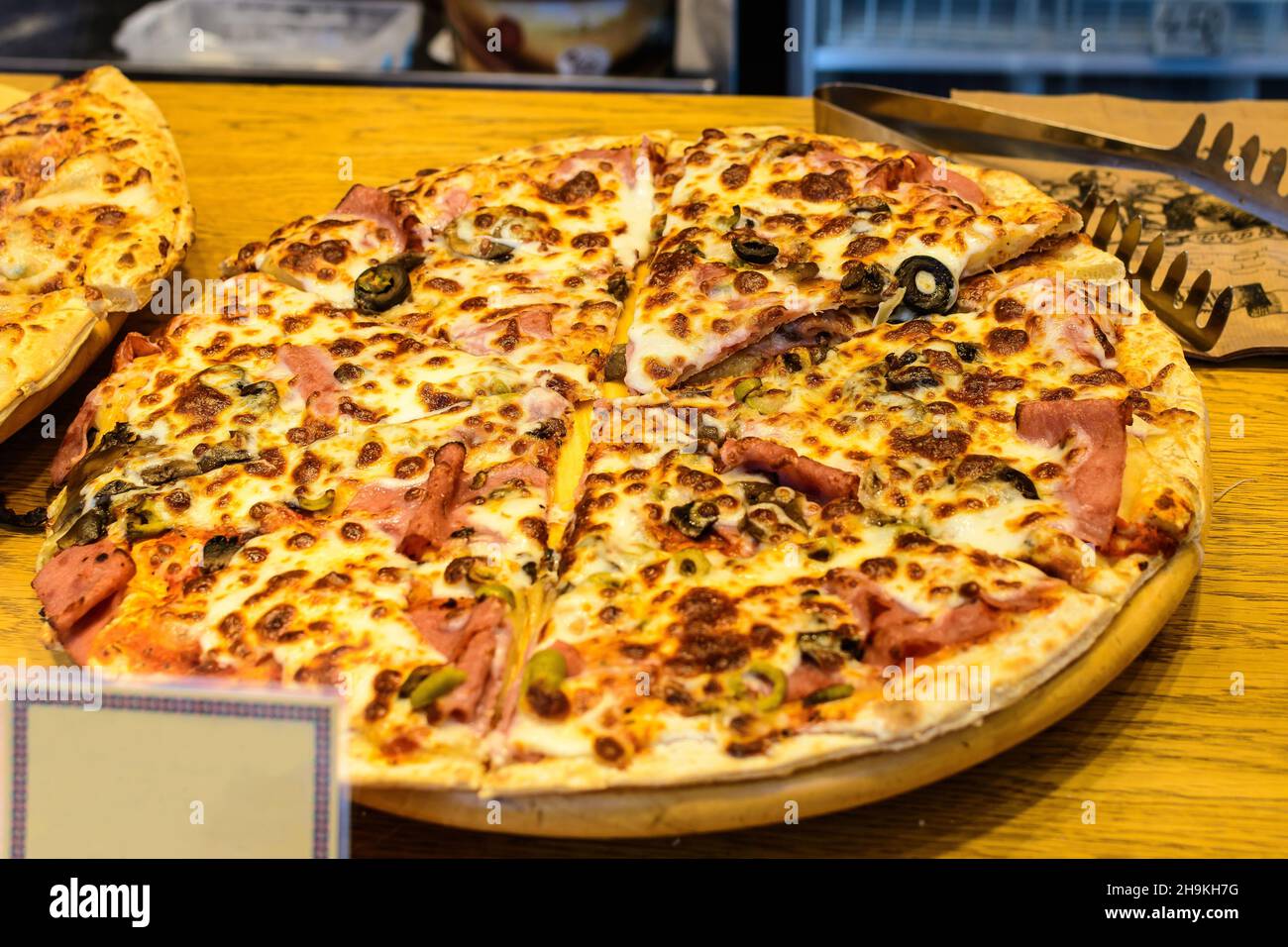 Traditional Italian pizza with prosciutto, mzozarella cheese and olives ...