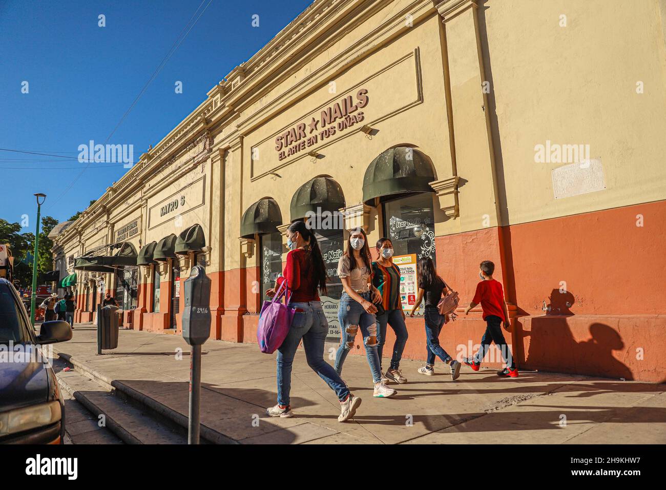 Two adolescent women walk in front of the facade of the Municipal ...