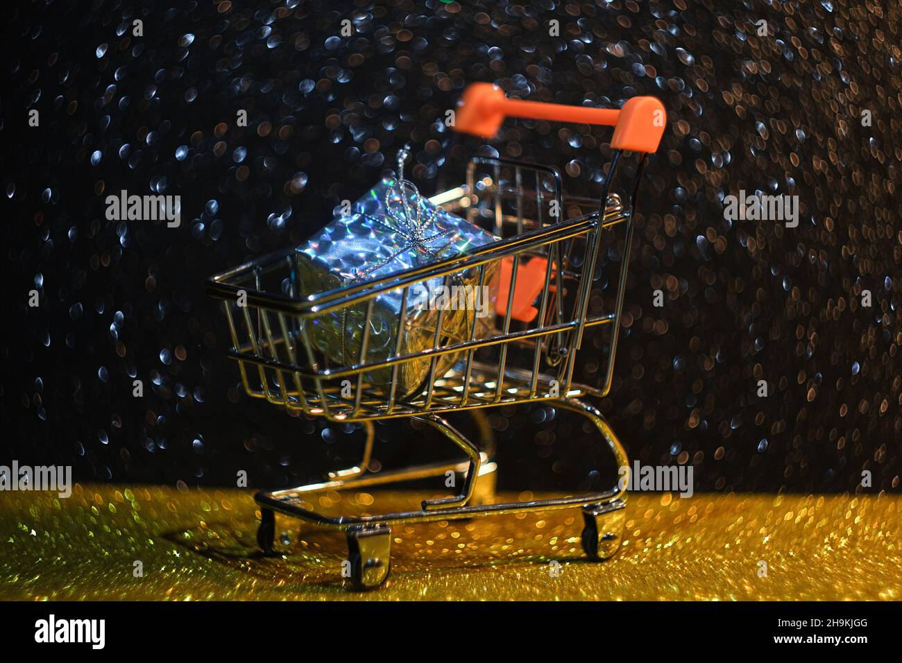 Shiny packaging in shopping cart with bokeh Stock Photo - Alamy