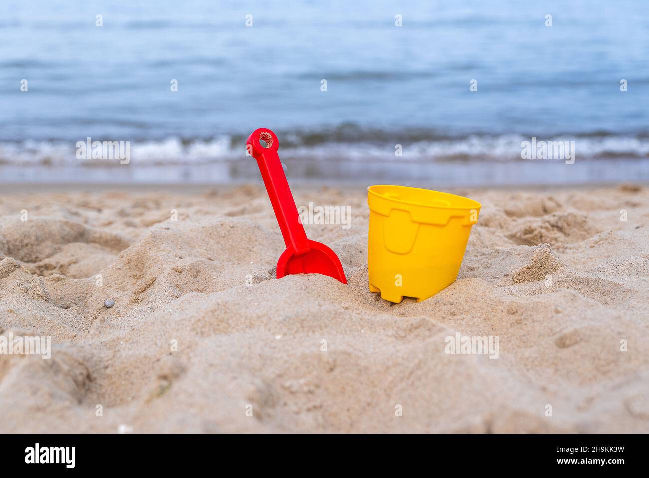 Plastic bucket with a shovel on the sandy beach Stock Photo - Alamy