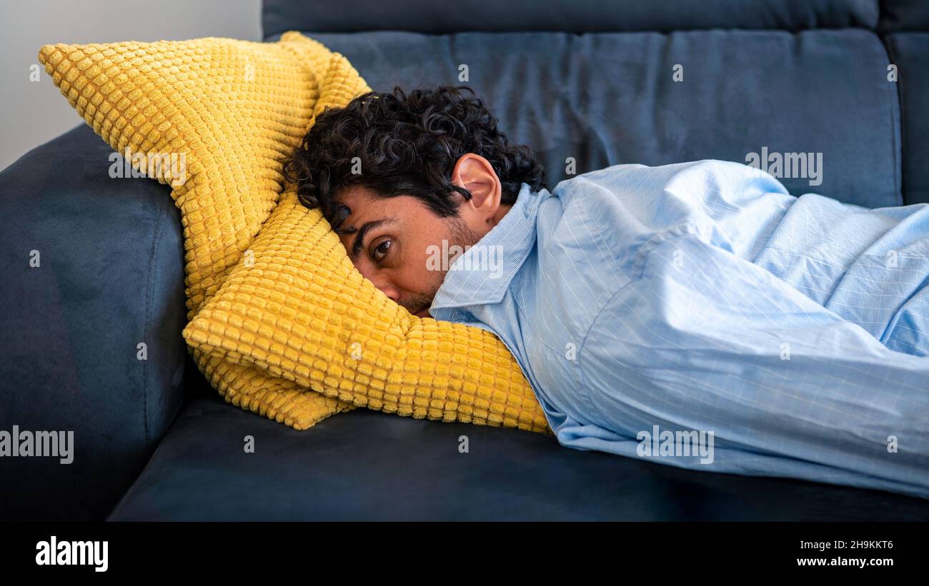 Tired frustrated millennial man at home, thinking over problems ...