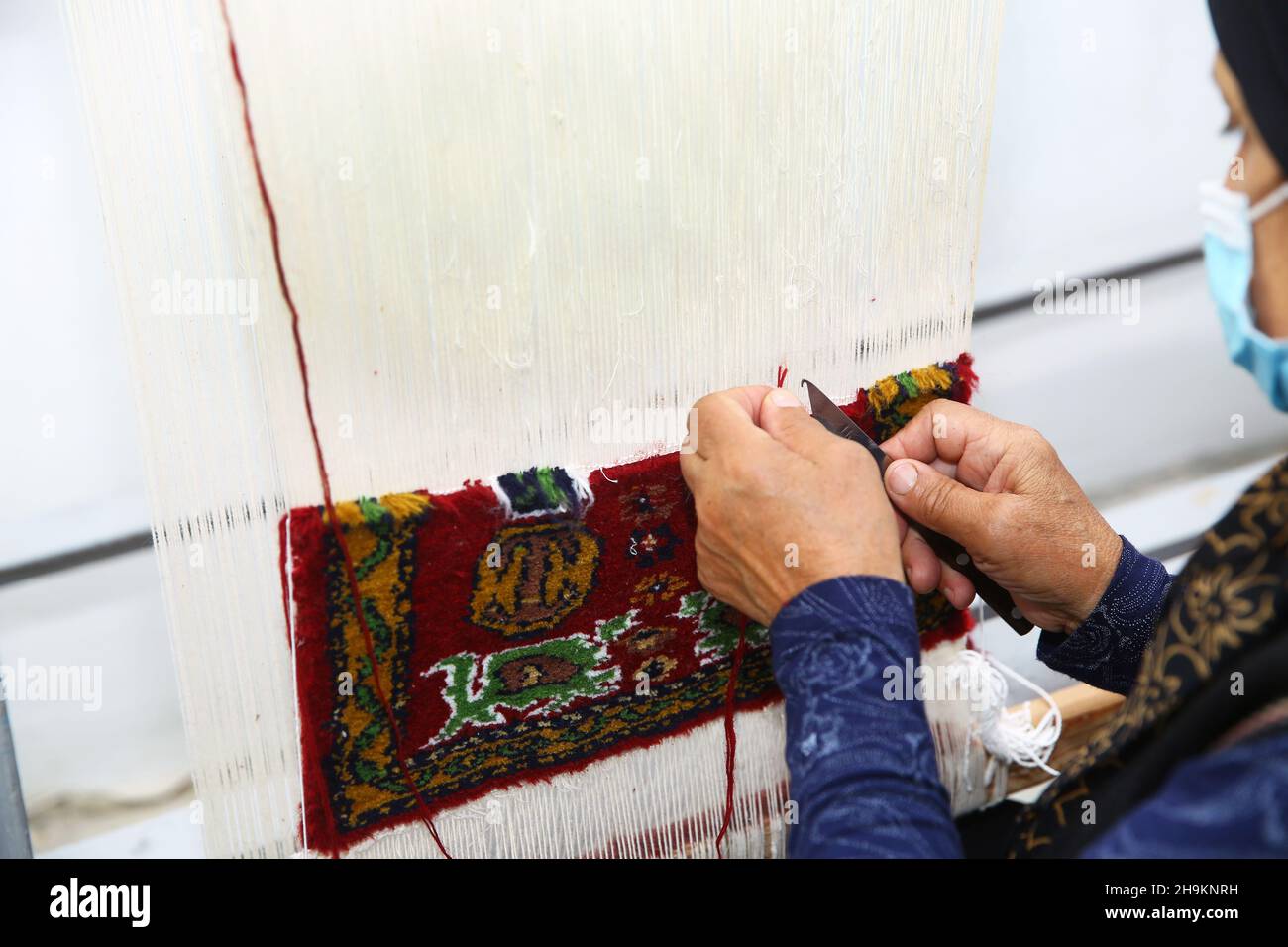 The woman weaving traditional carpet from Gala with colorful wool . The ...