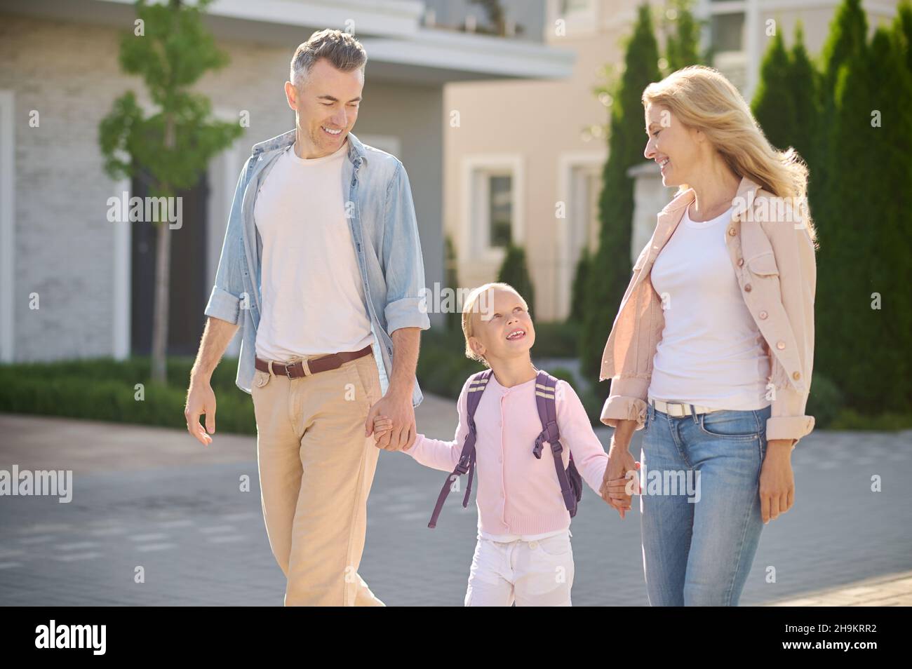 Parents and their daughter walking and holding hands Stock Photo - Alamy