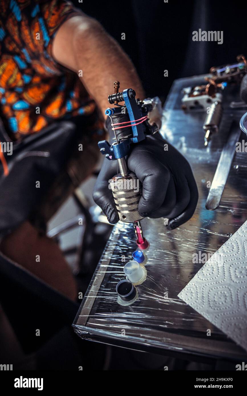 Hand of master of the art of tattooing with a tattoo machine./Hand of ...