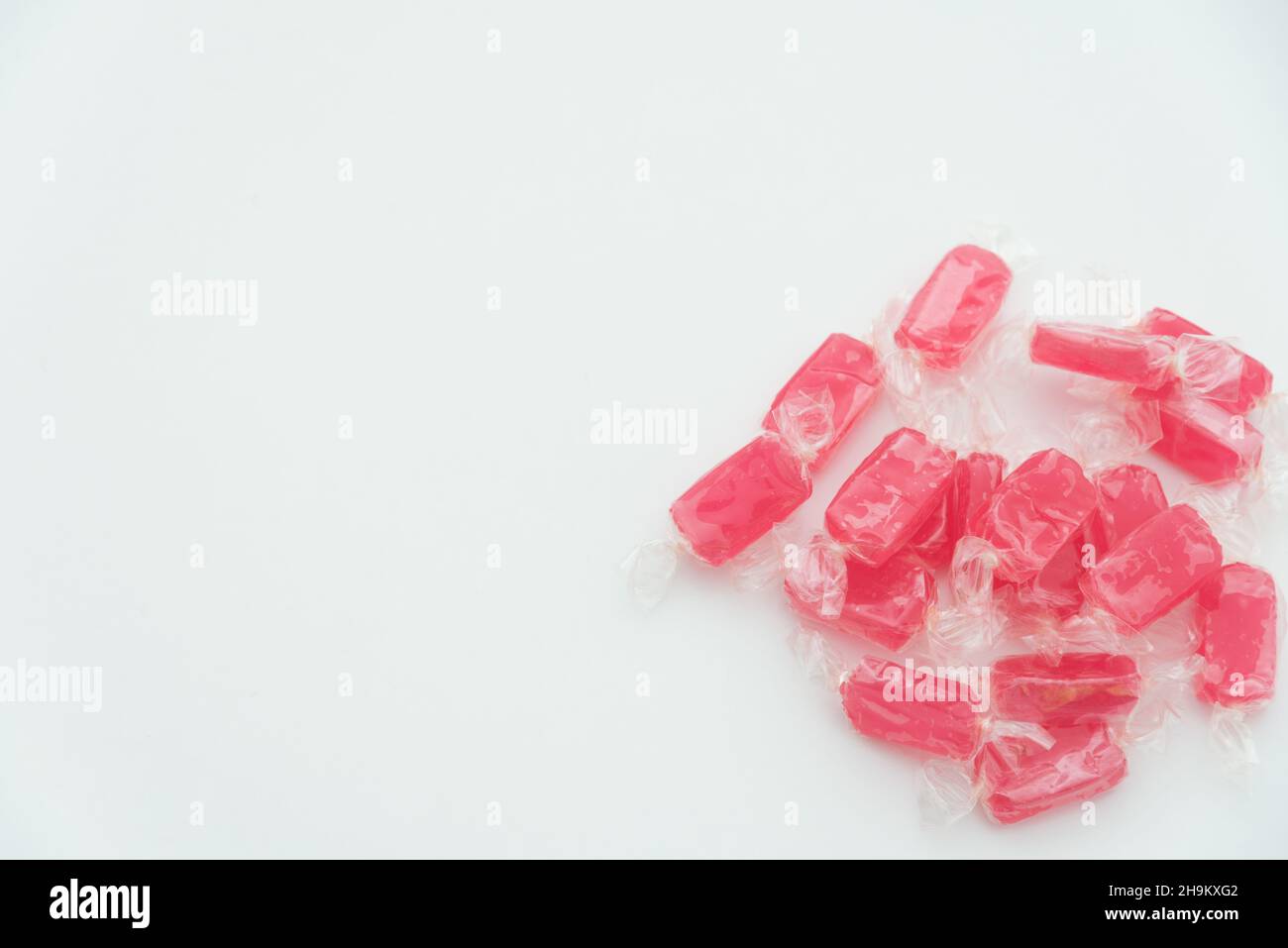 Red candies in transparent wrapper on white background close up top ...