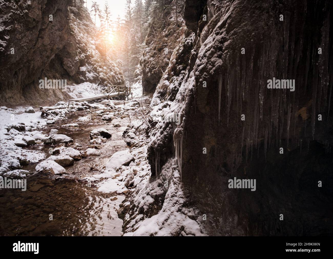 Flowing small creek running out icicle cave and washing big boulders ...