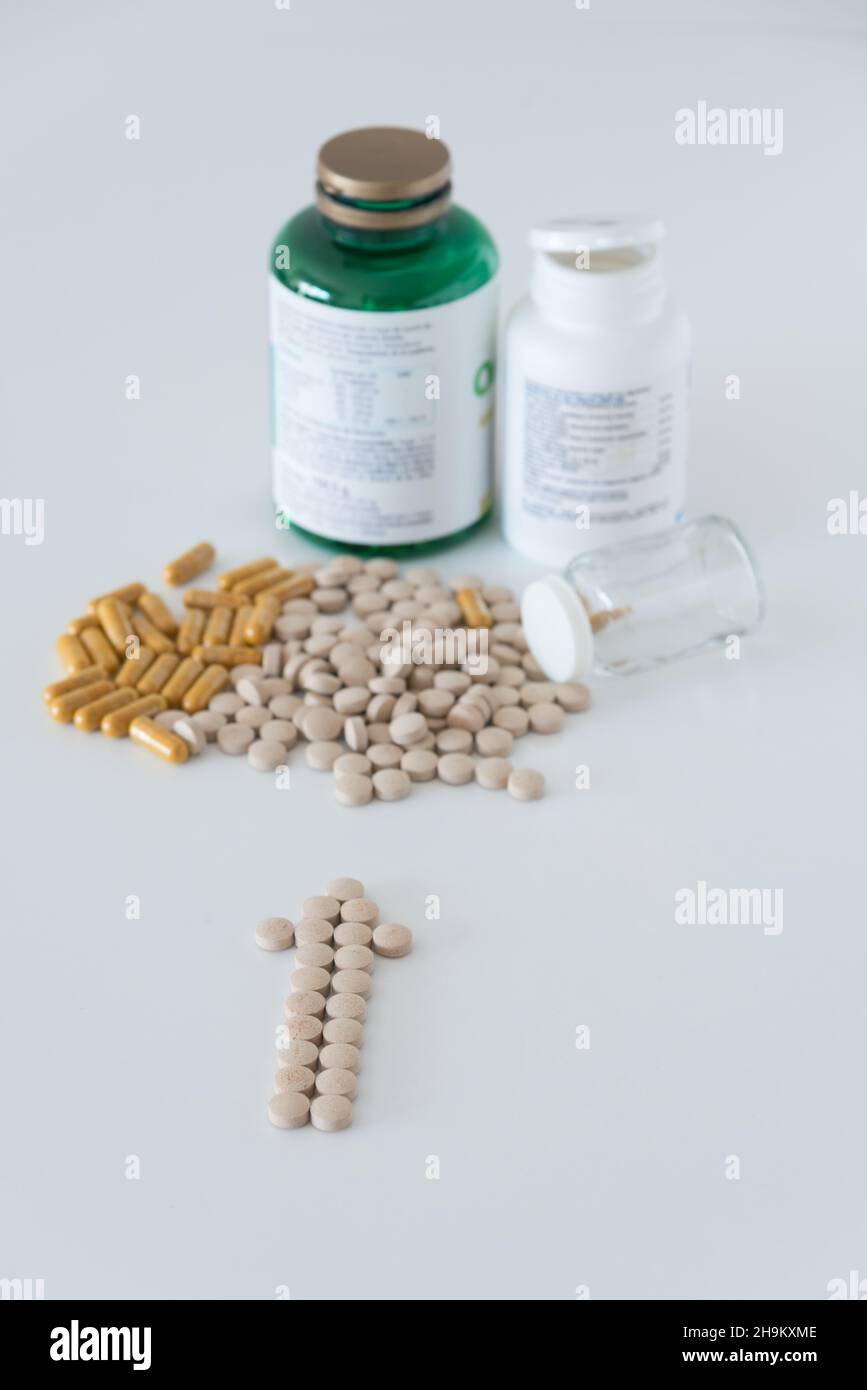 Transparent capsules with yellow powder and light brown pills on white ...