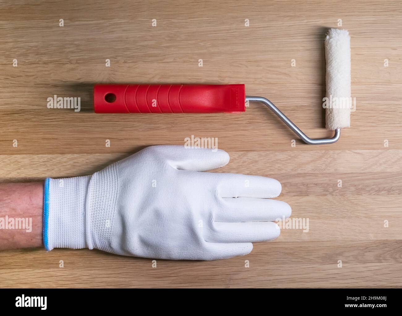 Paint roller and hand in glove ready to paint wood surface Stock Photo ...