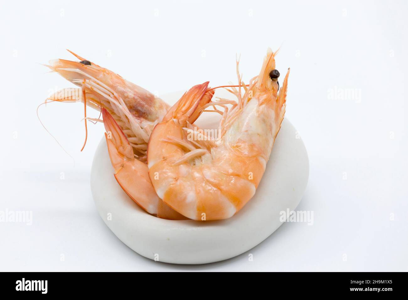 portrait of two cooked prawns in an original bowl and placed on white ...
