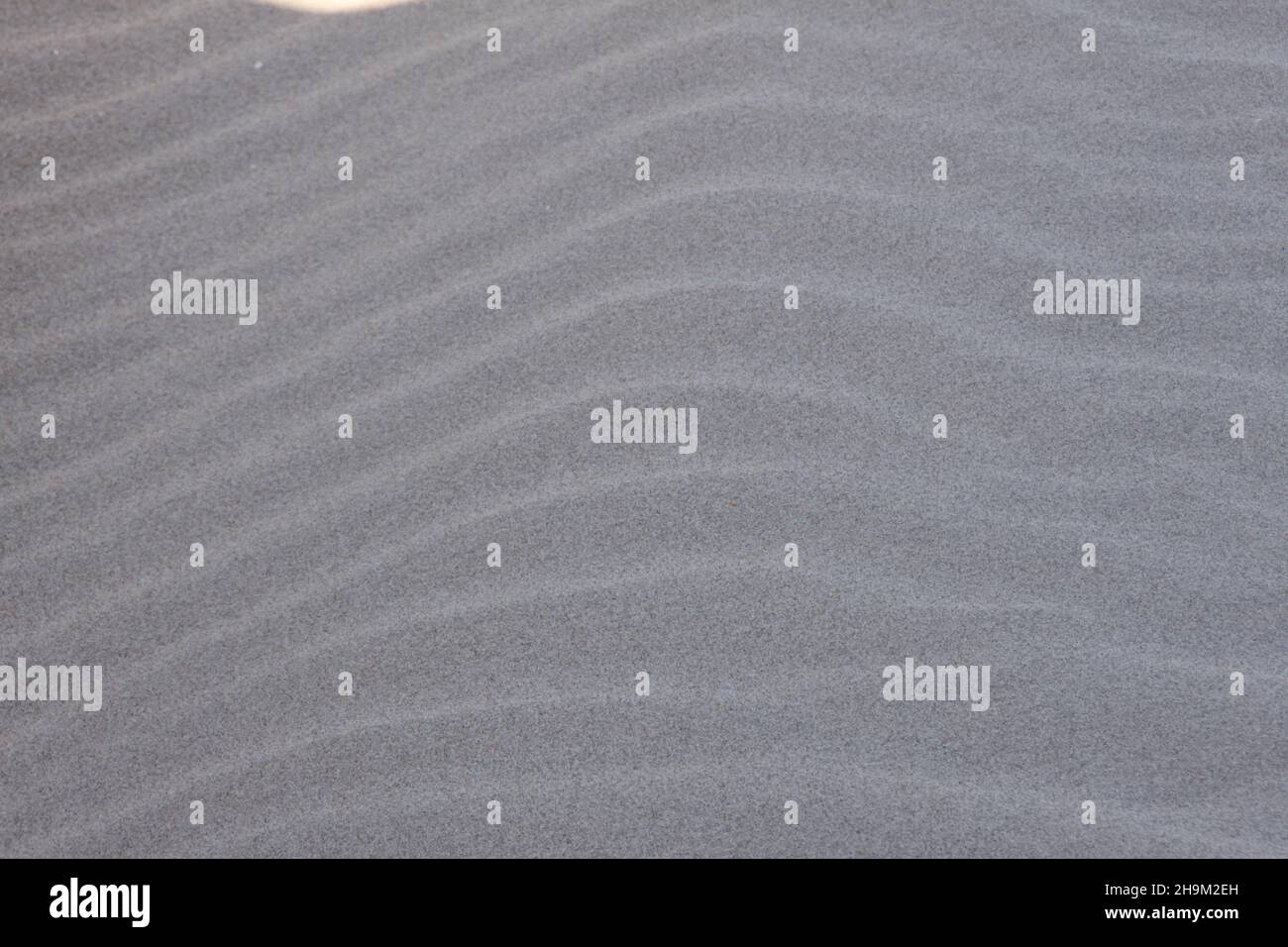 The pattern of waves in a grey sandy beach Stock Photo - Alamy