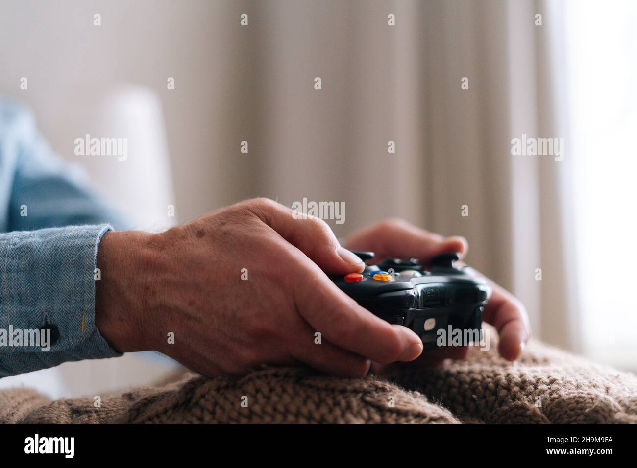 Close-up hands of unrecognizable senior male gamer playing online video ...