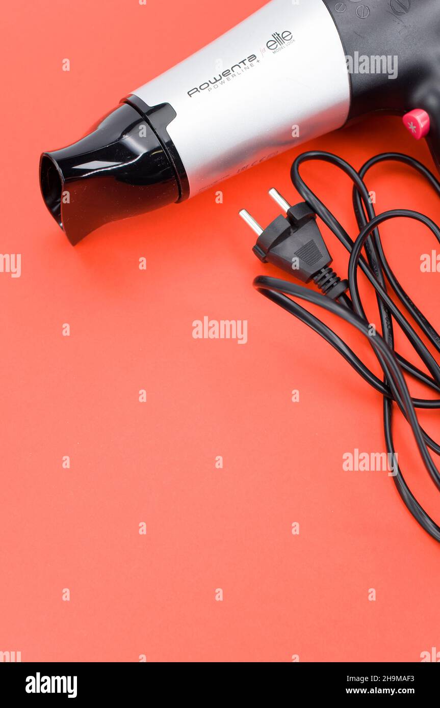 INVERIGO, ITALY - Dec 07, 2021: isolated hair dryer on a red background ...