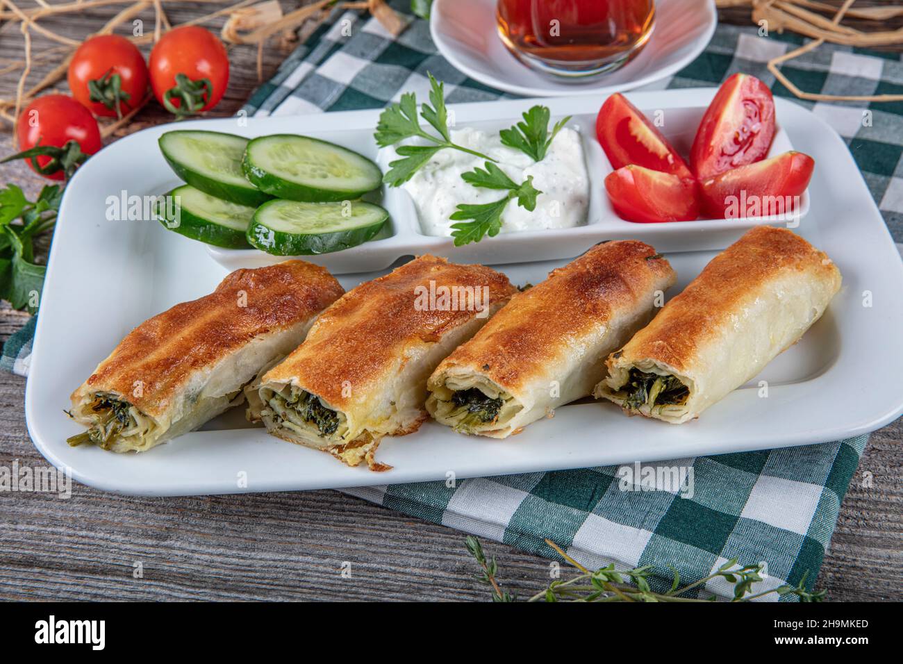 Turkish borek rolls with spinach on the white plate. A traditional ...