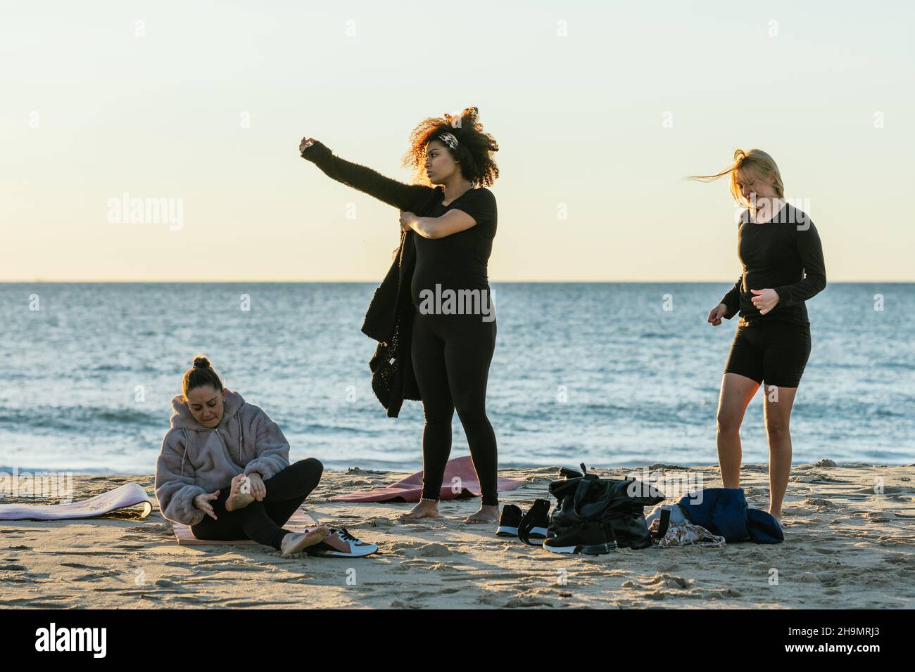 Members of a yoga class putting on clothes after a yoga class on the ...