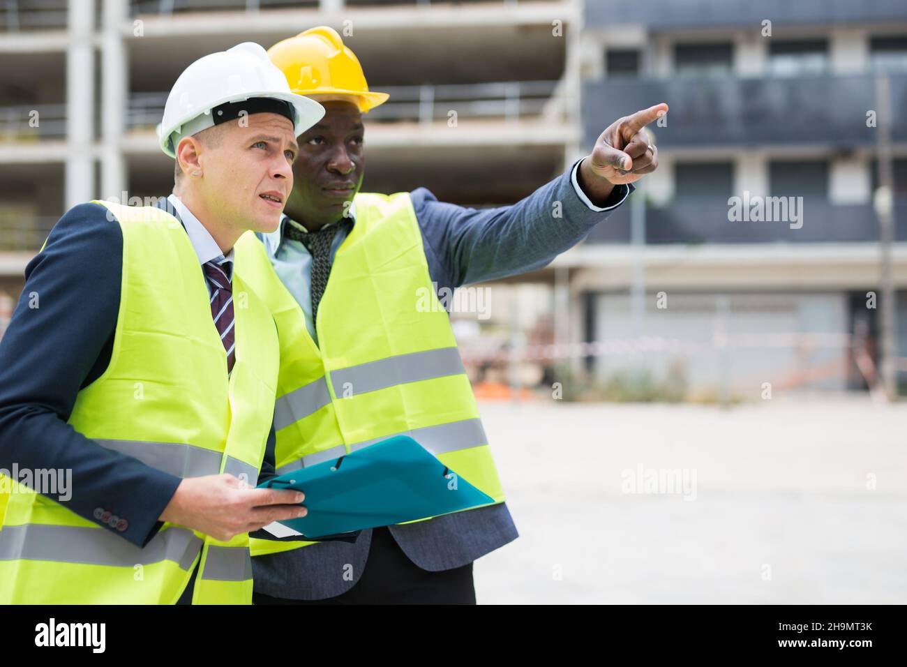 African-american engineer discussing a construction plan with a ...