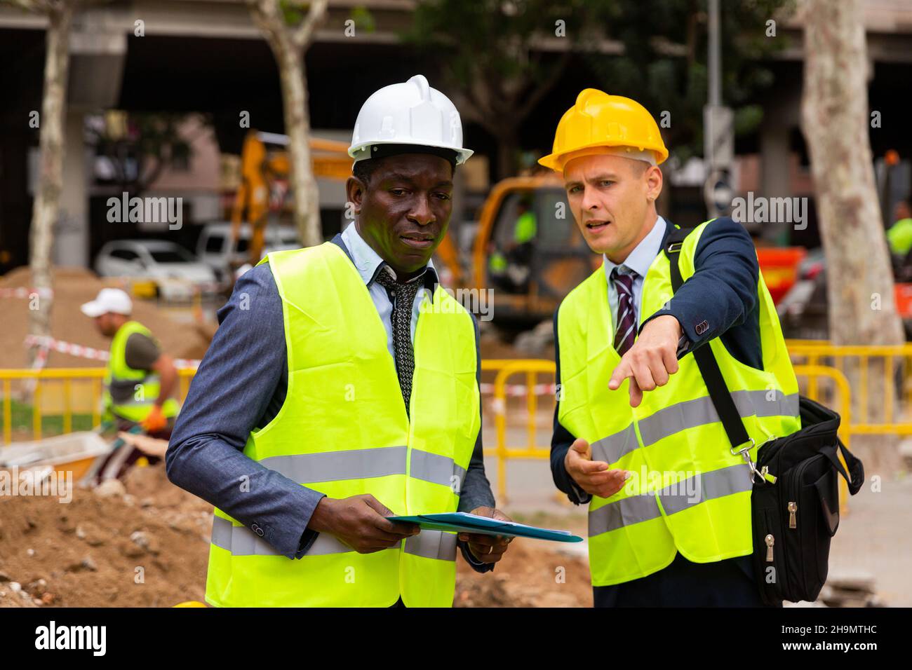 Architect tells engineer where to dig a trench to lay pipe Stock Photo ...
