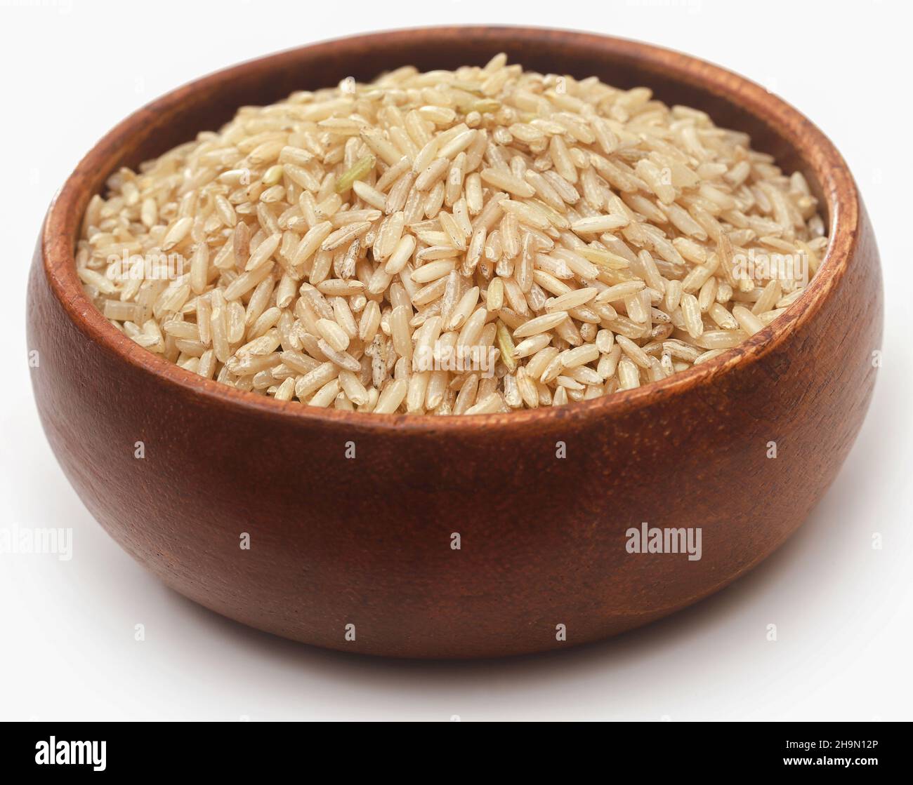 Uncooked brown rice in a bowl over white Stock Photo - Alamy