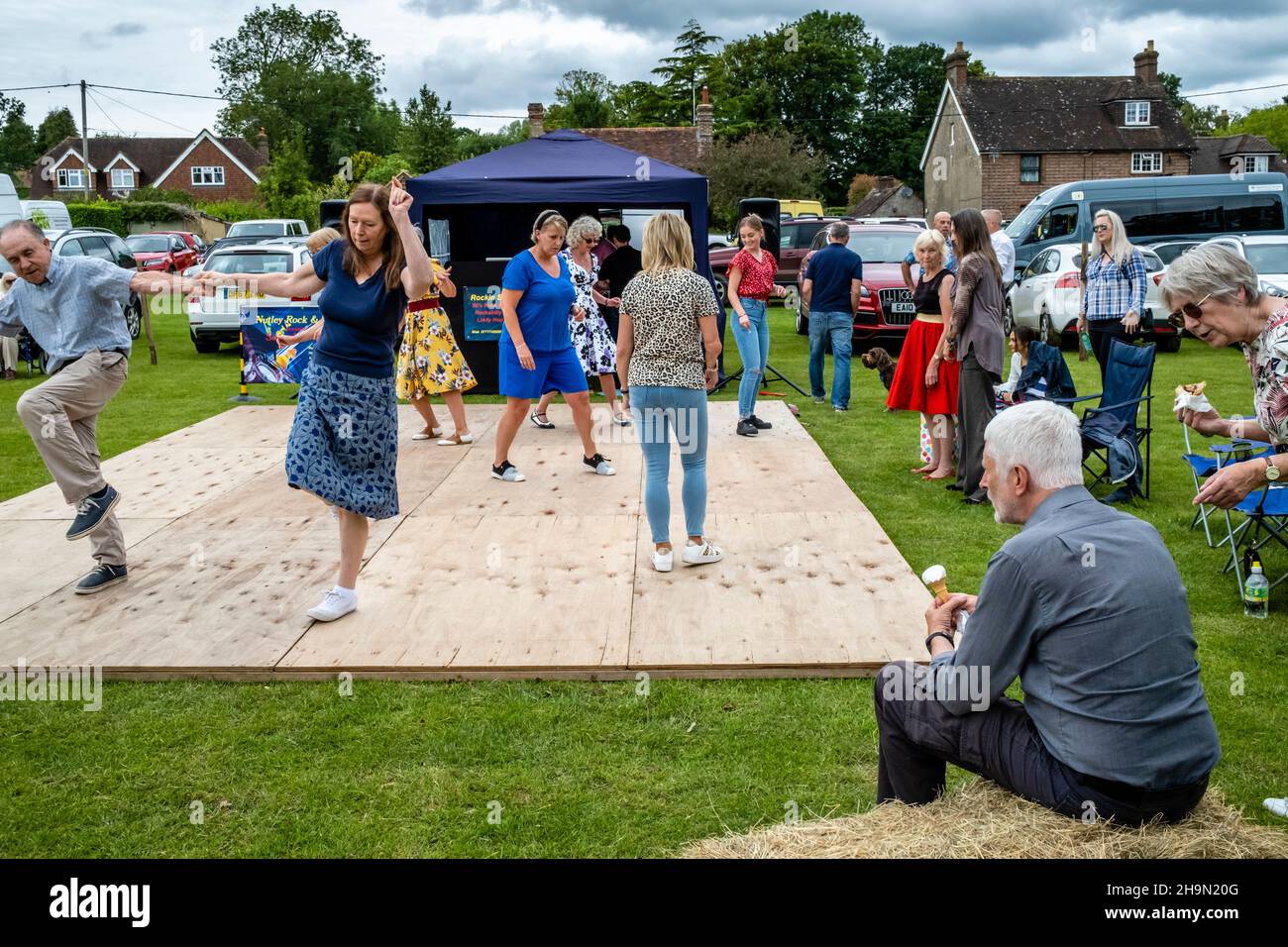A Man Eats An Ice Cream Whilst Watching Local People Dancing At The ...