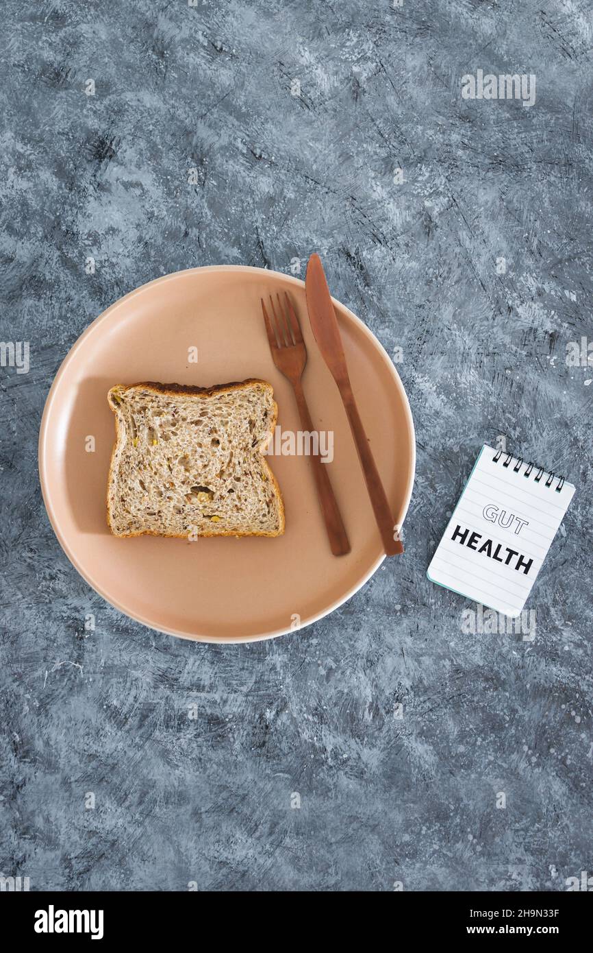 gut health notepad next to wholegrain multiseeds slice of bread on ...