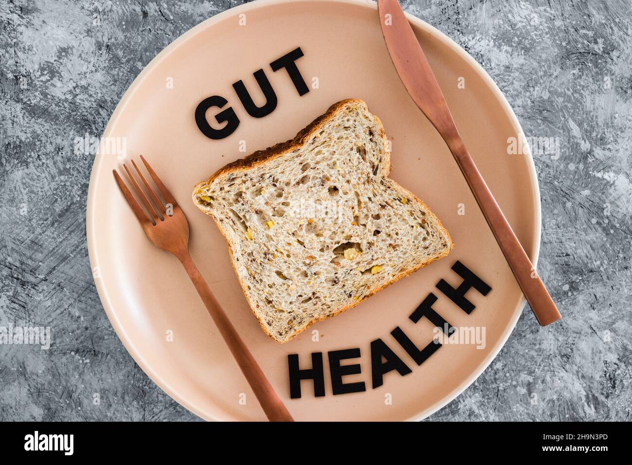 gut health text with wholegrain multiseeds slice of bread on dining ...