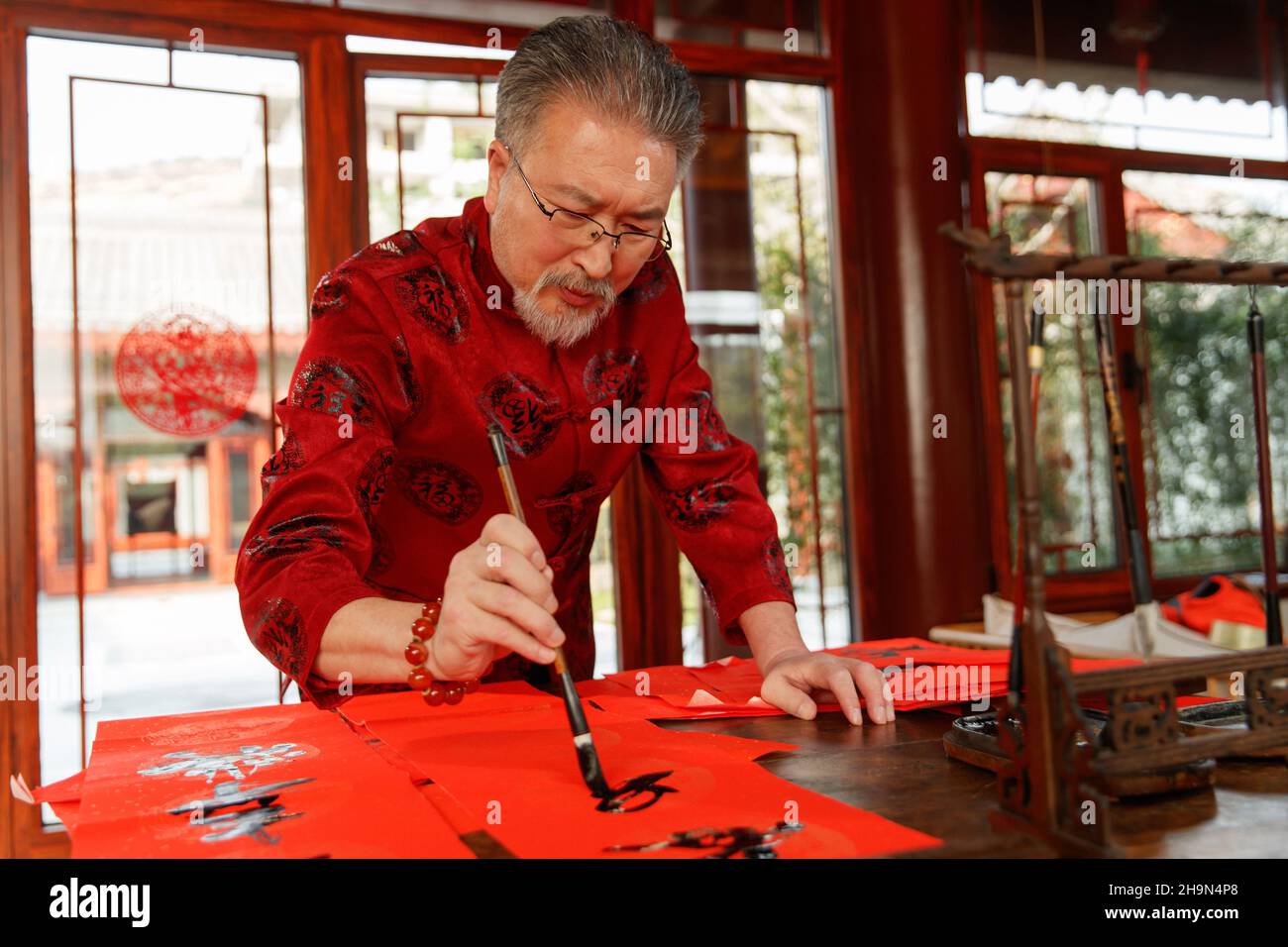 Older men write calligraphy Stock Photo - Alamy