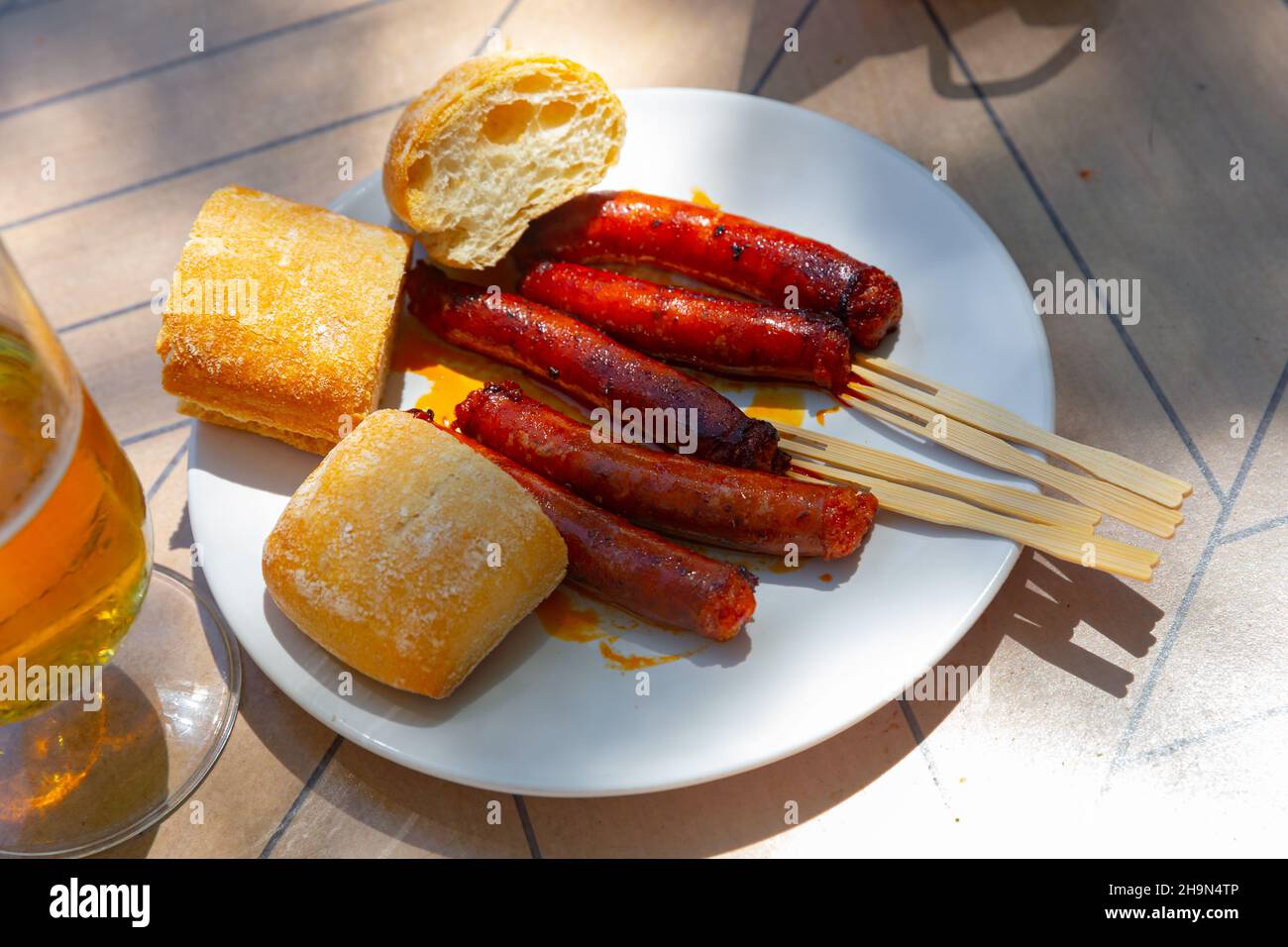 Mildly spiced grilled mini sausages chistorra. Tapa from Basque Country ...