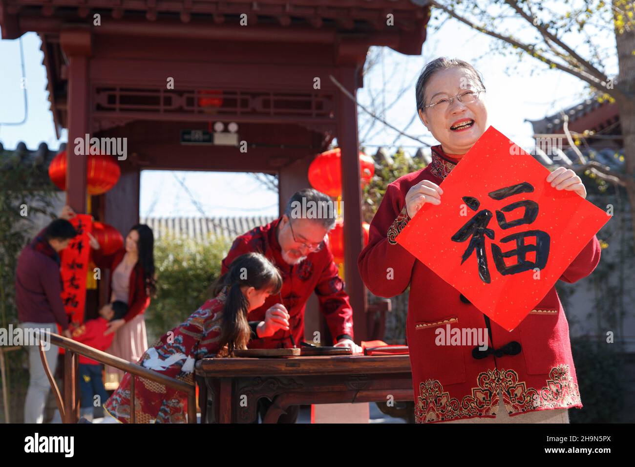 Happy New Year family write Spring Festival couplets Stock Photo - Alamy