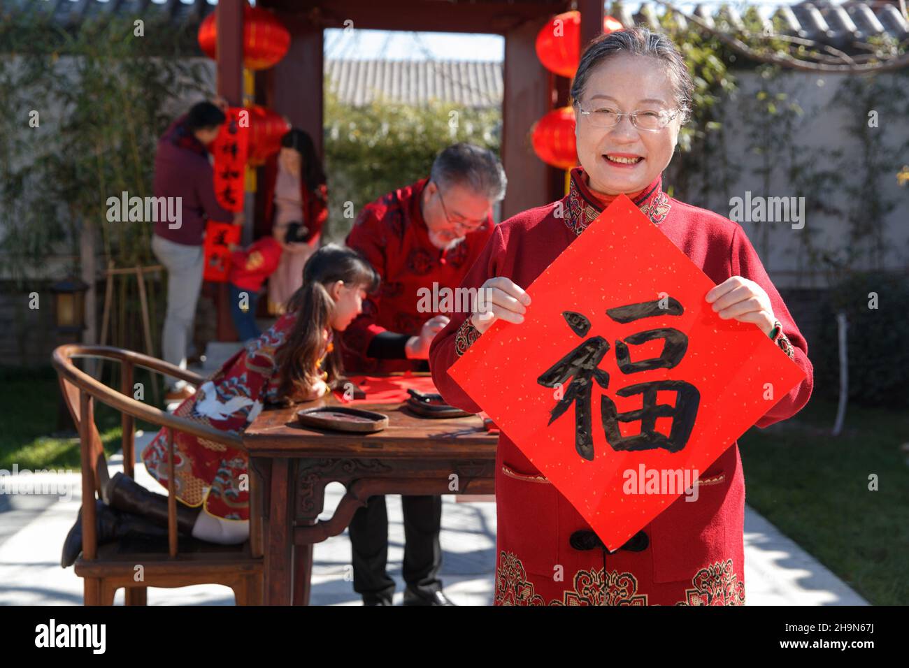 Happy New Year family write Spring Festival couplets Stock Photo - Alamy