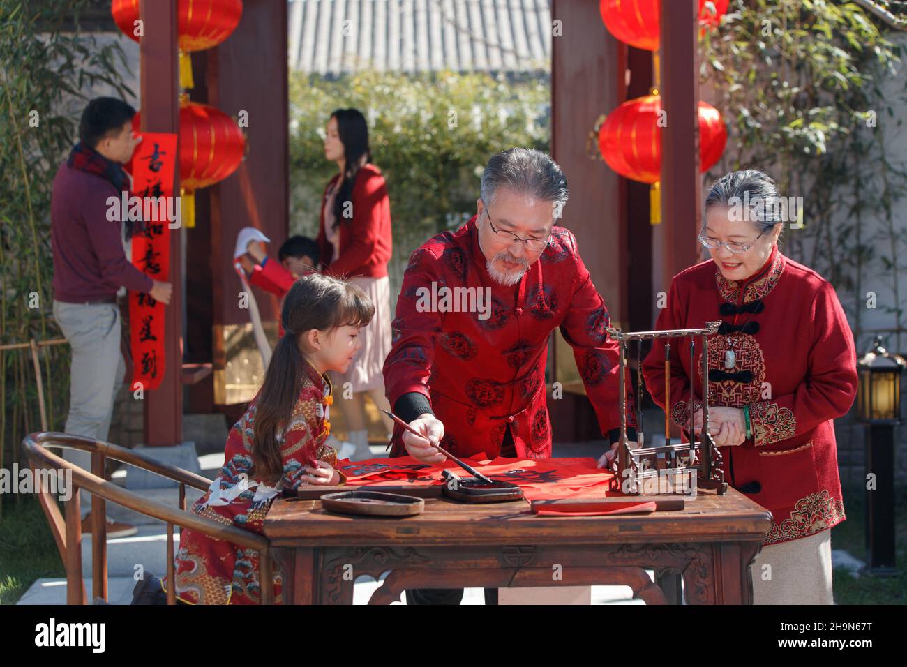Happy New Year family write Spring Festival couplets Stock Photo - Alamy