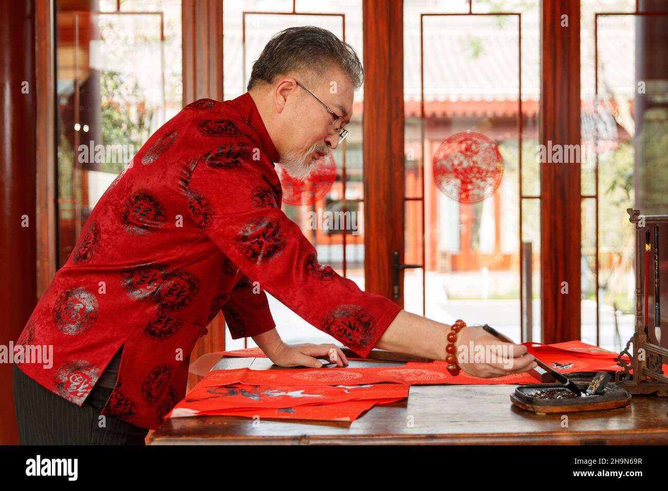 Older men write calligraphy Stock Photo - Alamy
