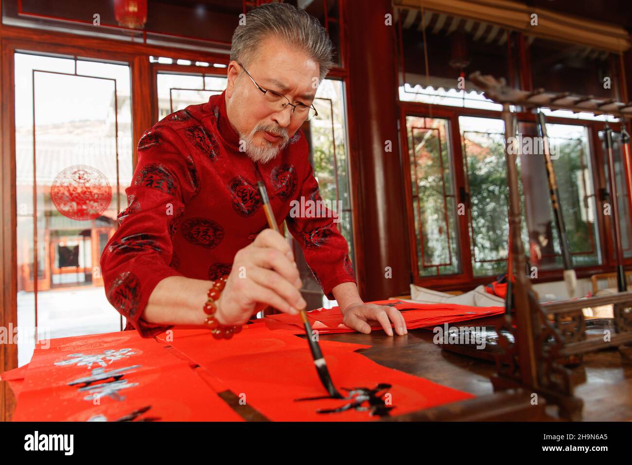 Older men write calligraphy Stock Photo - Alamy